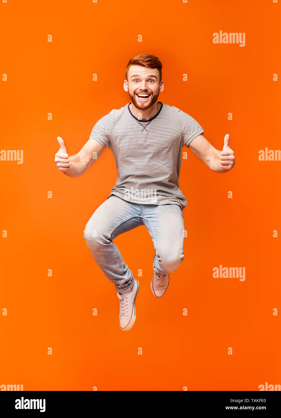 Happy joyful man jumping up in air, demonstrating thumbs up Stock Photo ...