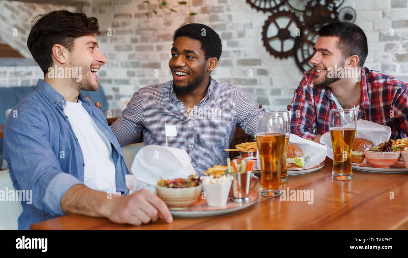 Three men enjoying at the restaurant hi-res stock photography and ...