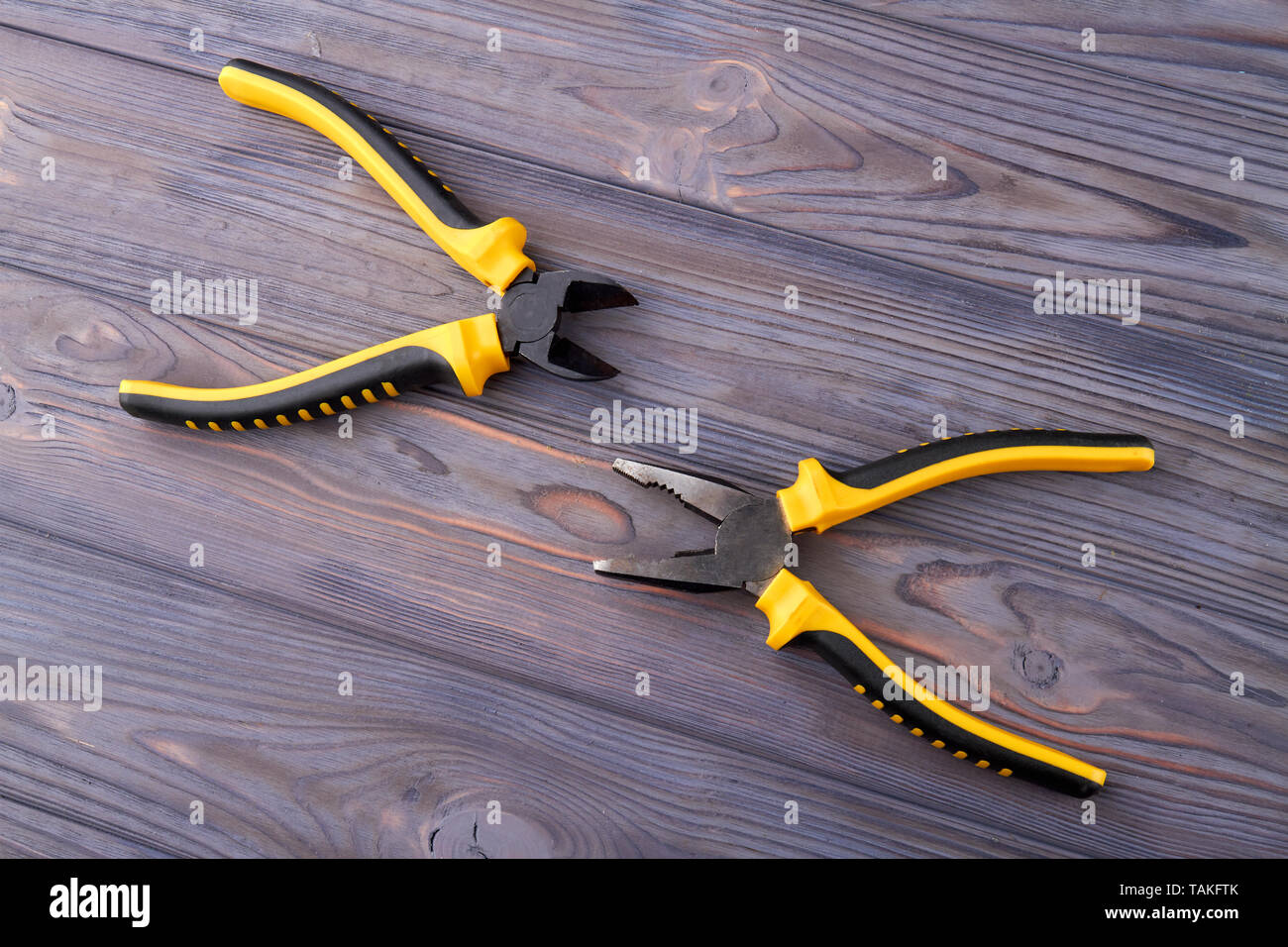Construction tools on woden table. Two pairs of pliers with insulated ...