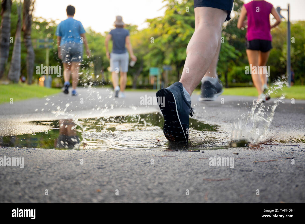 Man exercise running through puddle splashing his shoes Stock Photo - Alamy