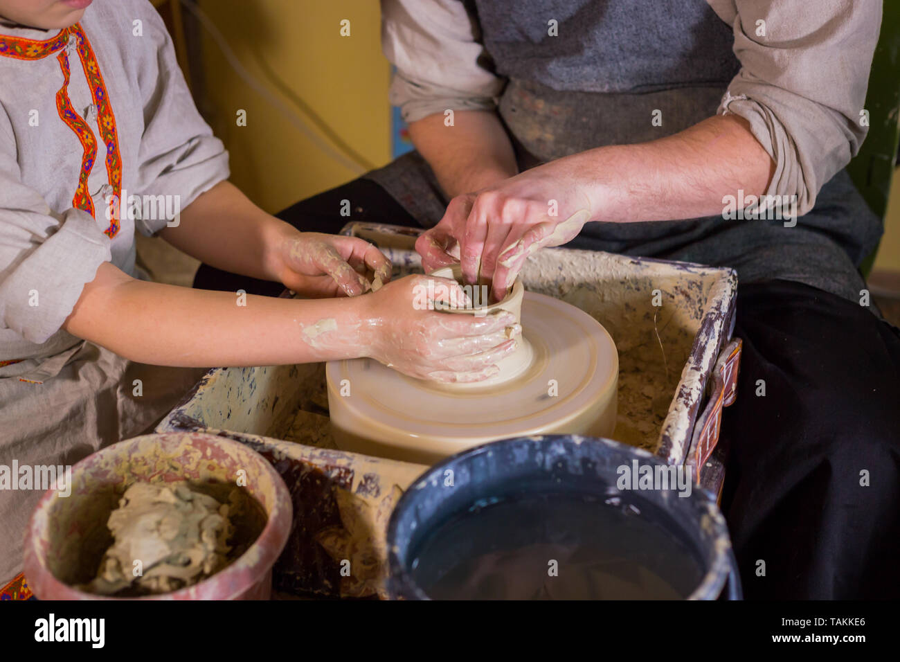 Pottery class and workshop: professional male potter working with boy ...