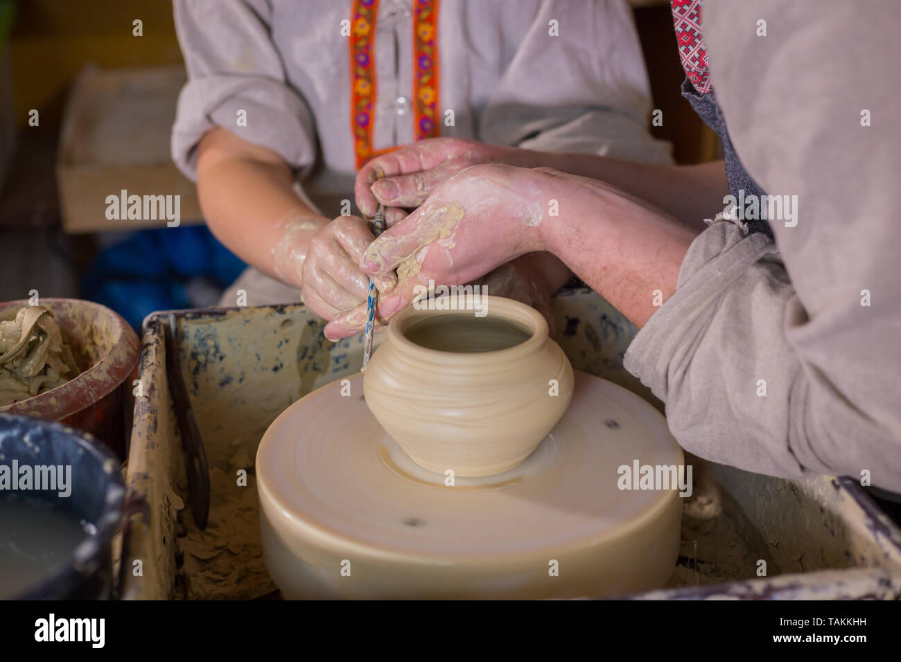 Pottery class and workshop: professional male potter working with boy ...