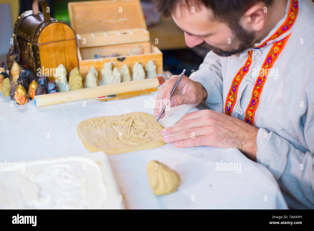 Professional male potter making clay stamp picture. Handwork, crafting ...