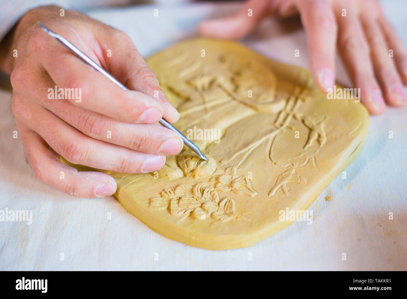 Professional male potter making clay stamp picture. Handwork, crafting ...