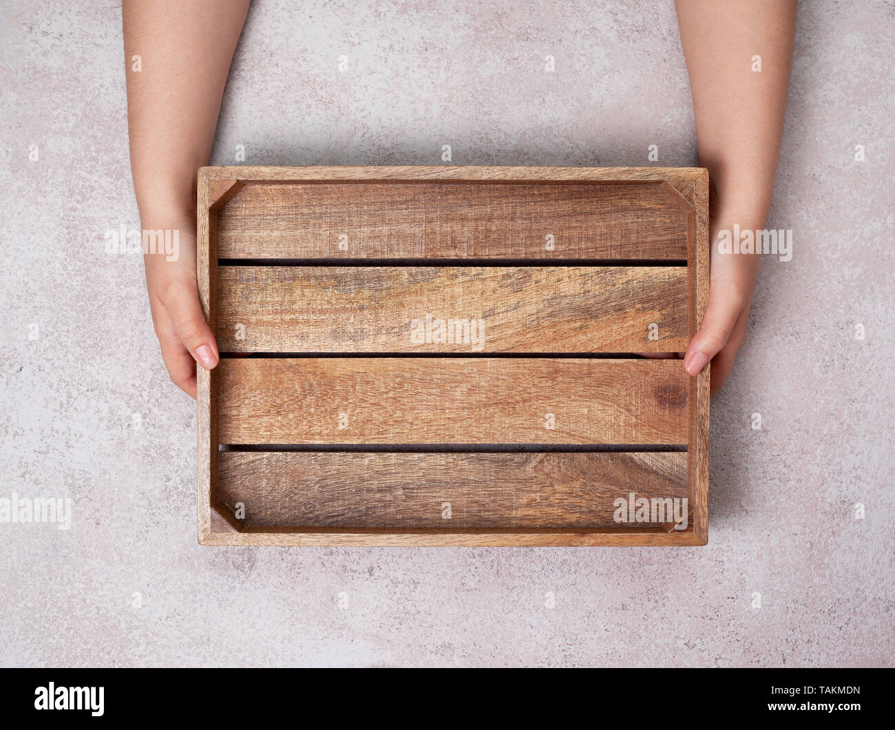 Female hands hold an empty wooden tray. view from above. copy space ...