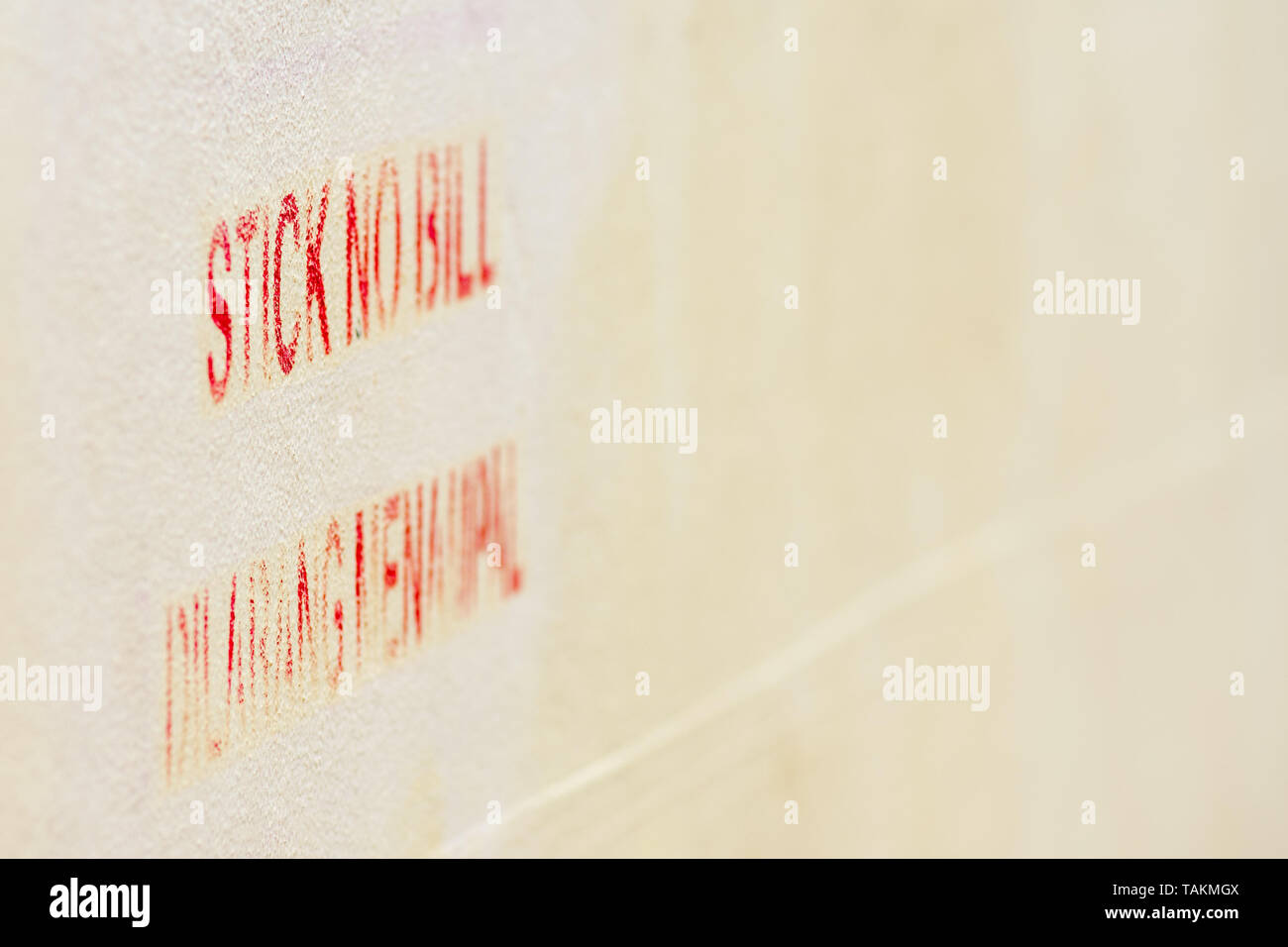 'Stick No Bill' Stencil spray painted in red to cream wall Stock Photo ...