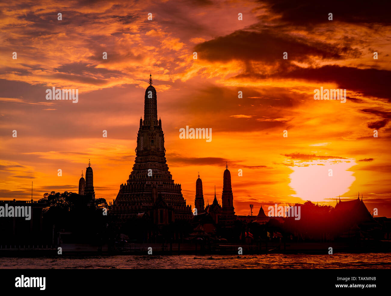 Wat Arun Ratchawararam at sunset with beautiful red and orange sky and ...