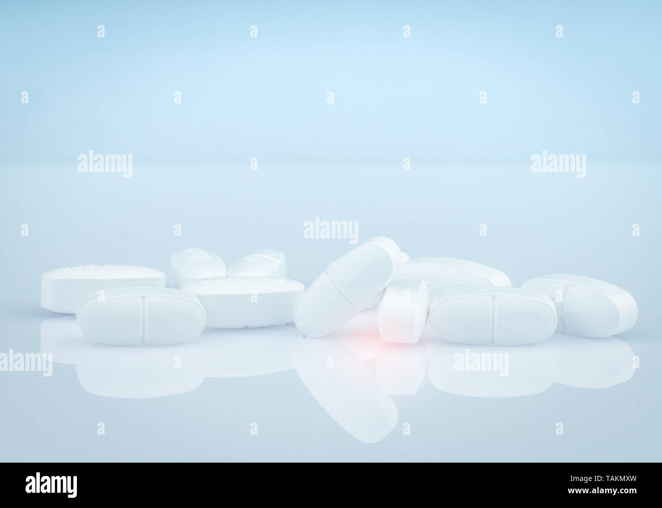 Pile of white oblong tablets pills on gradient background. White ...