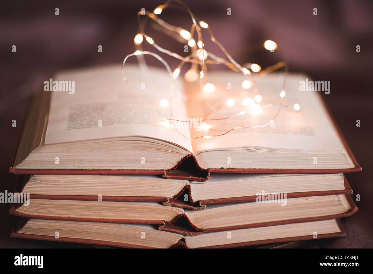 Stack of old books with lights closeup. Home library. Education concept ...