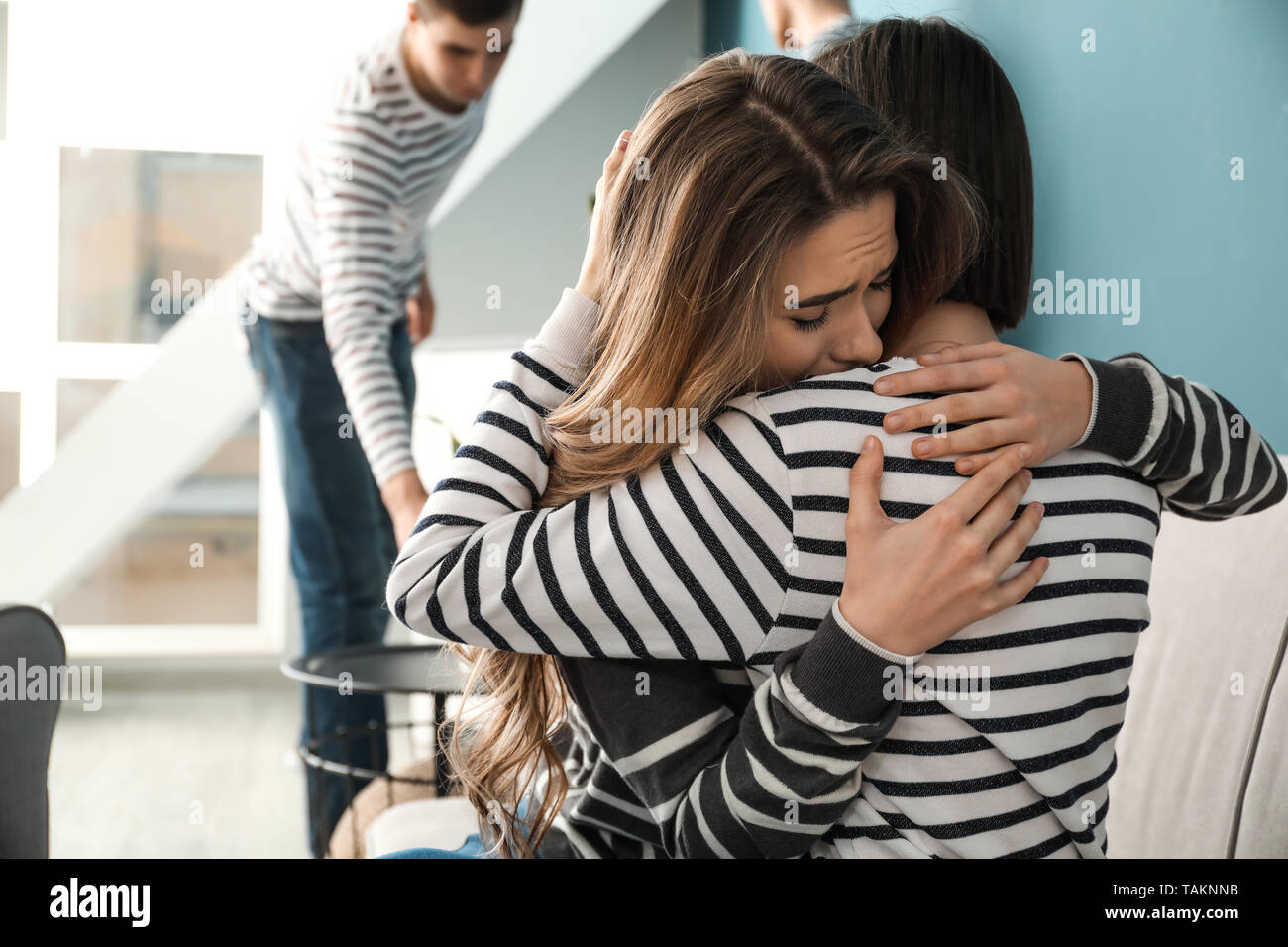 Young woman calming her friend indoors Stock Photo - Alamy