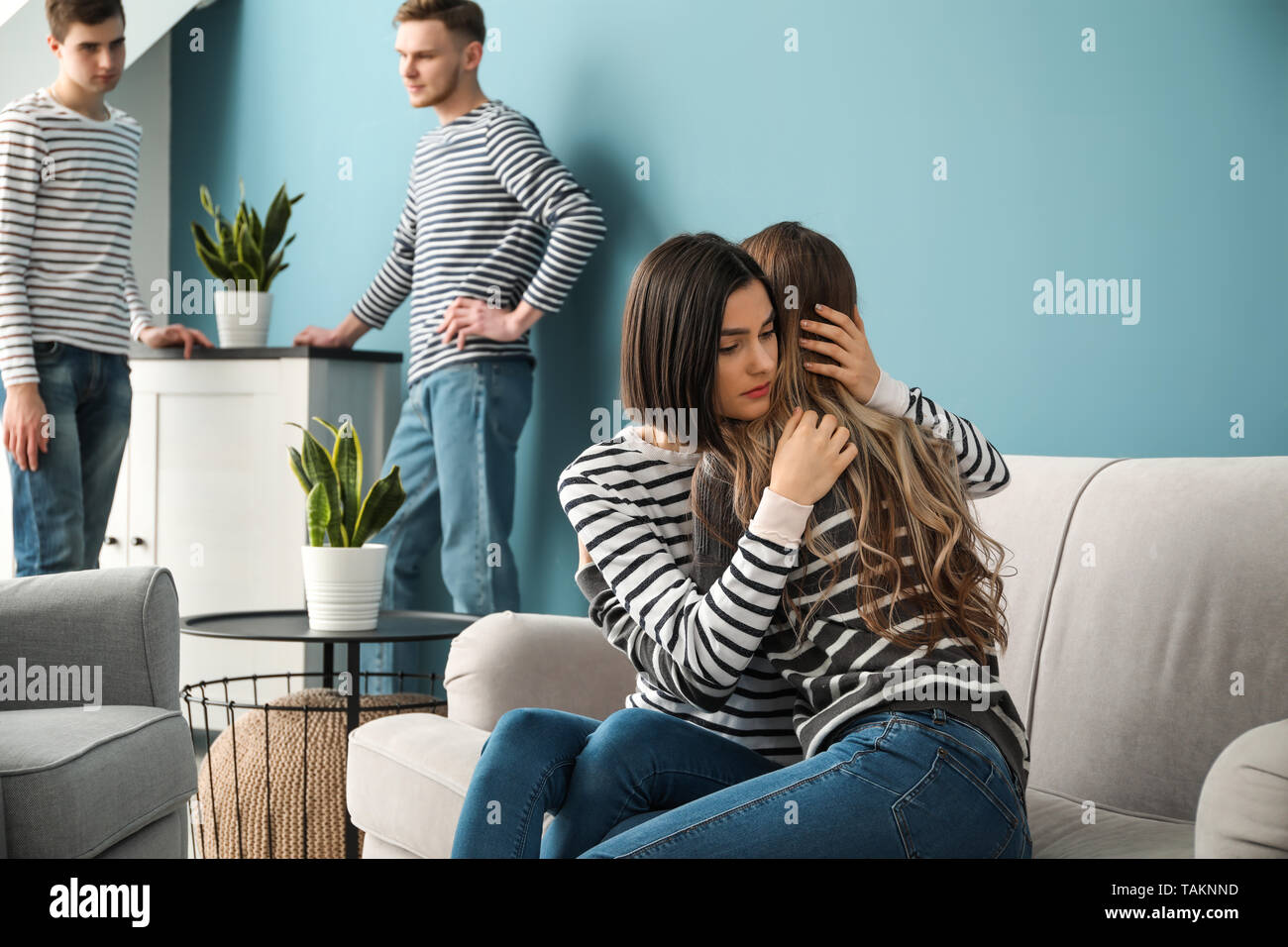 Young woman calming her friend indoors Stock Photo - Alamy