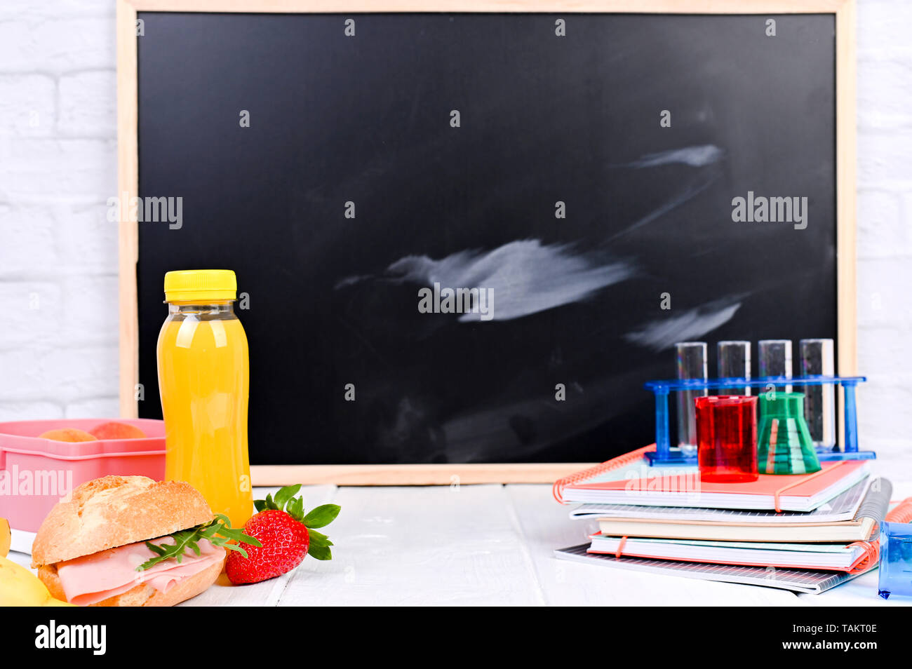 School lunch on the table and a blackboard for a lesson. Children's ...