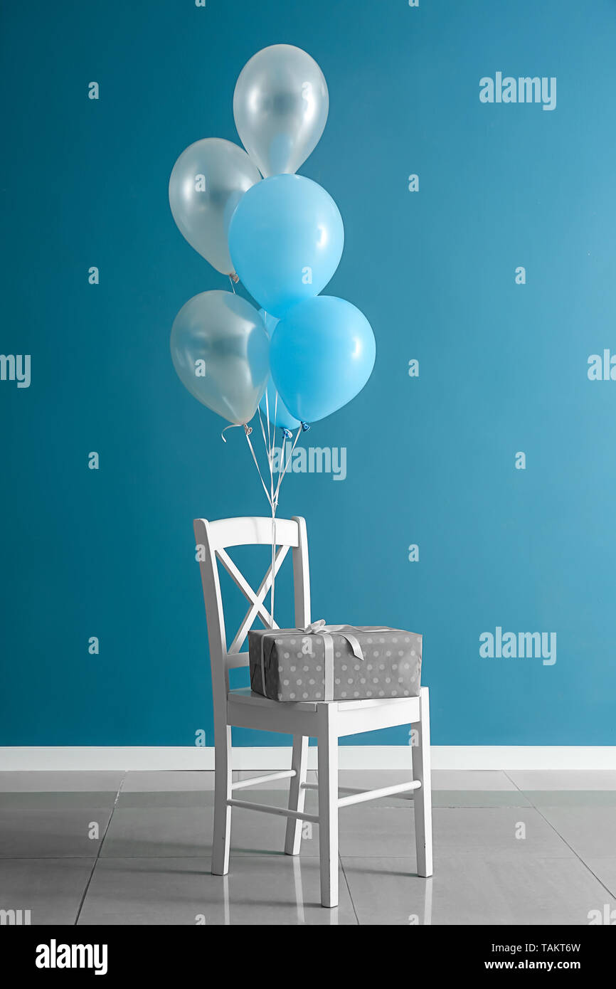 Chair with birthday balloons and gift box in room Stock Photo - Alamy