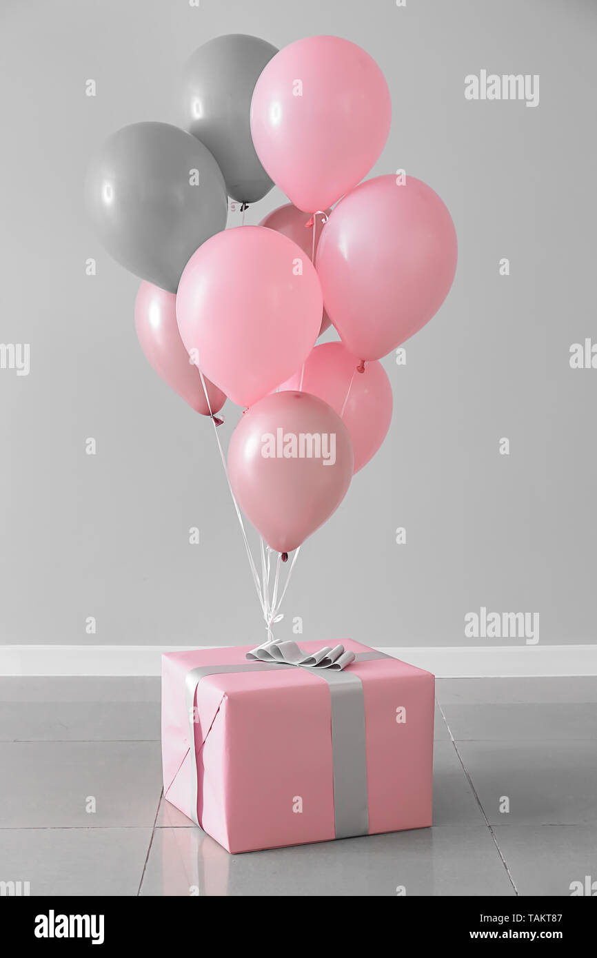 Birthday balloons with gift box in room Stock Photo - Alamy
