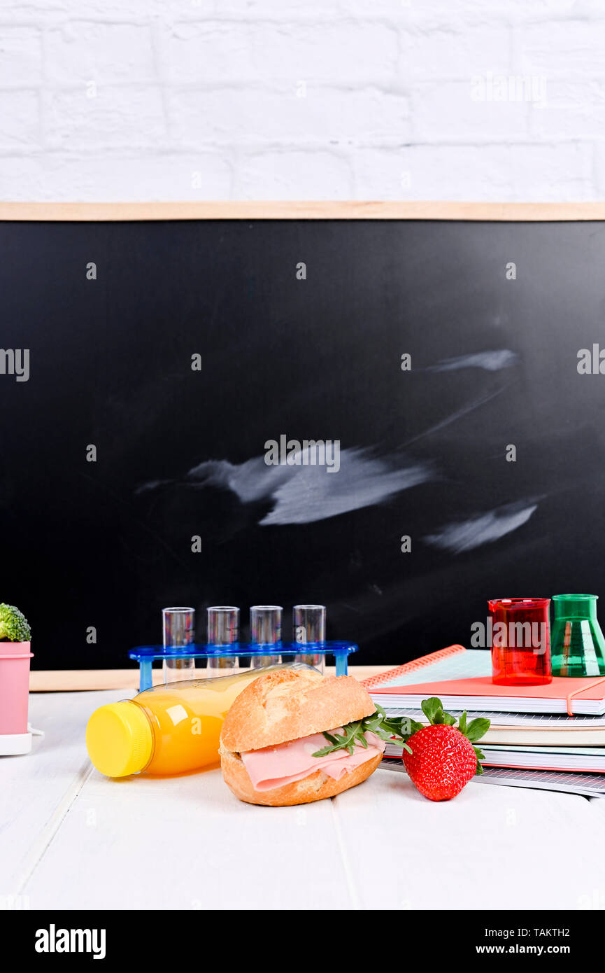 School lunch on the table and a blackboard for a lesson. Children's ...