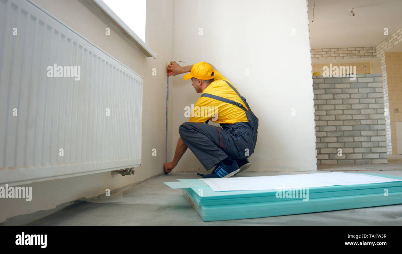 Builder measuring wall with a ruler. Apartment renovation background ...