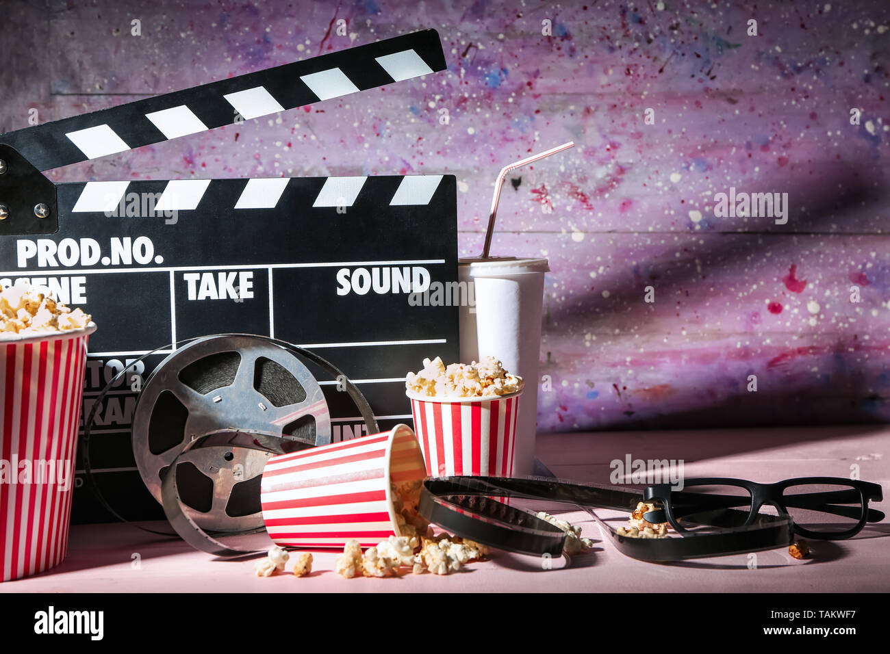 Movie clapper with film reel and popcorn on table Stock Photo - Alamy