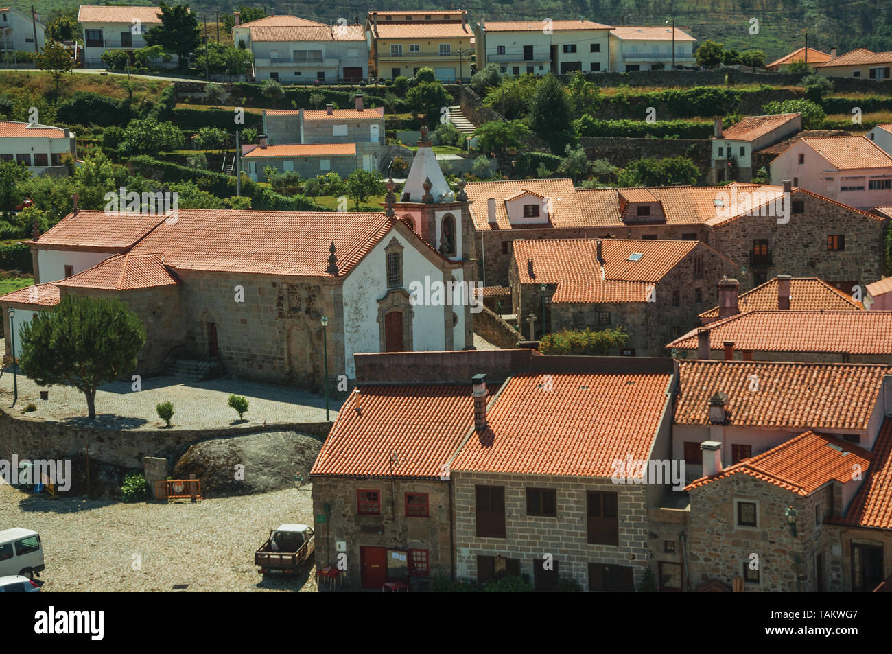 Hilly landscape covered by trees with the church and roofs of Linhares ...