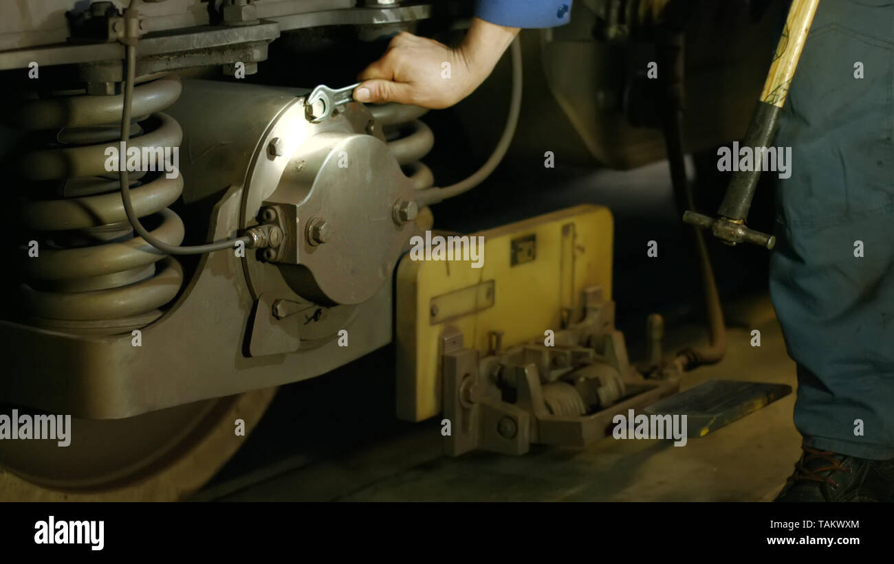 Mechanic repairing train at the depot. Wheel of subway train close up ...