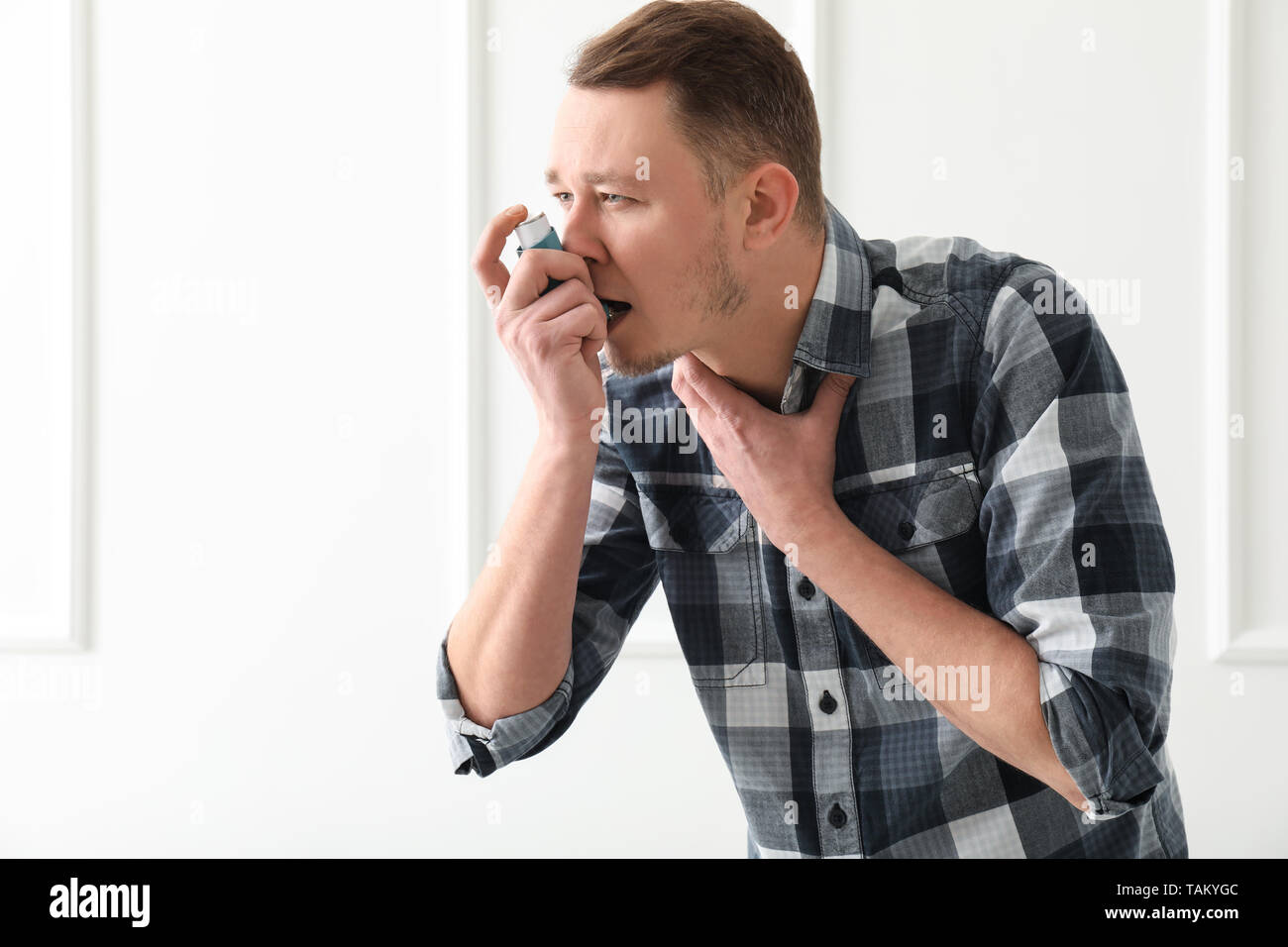 Man with inhaler having asthma attack on white background Stock Photo ...