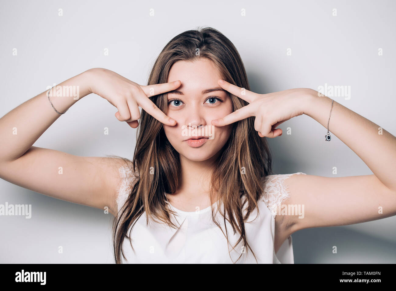 Beautiful brunette woman showing dancing gesture on white background ...