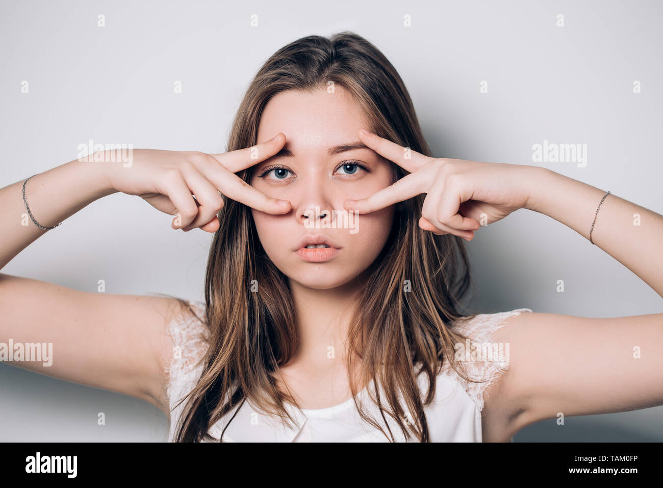 Beautiful brunette woman showing dancing gesture on white background ...