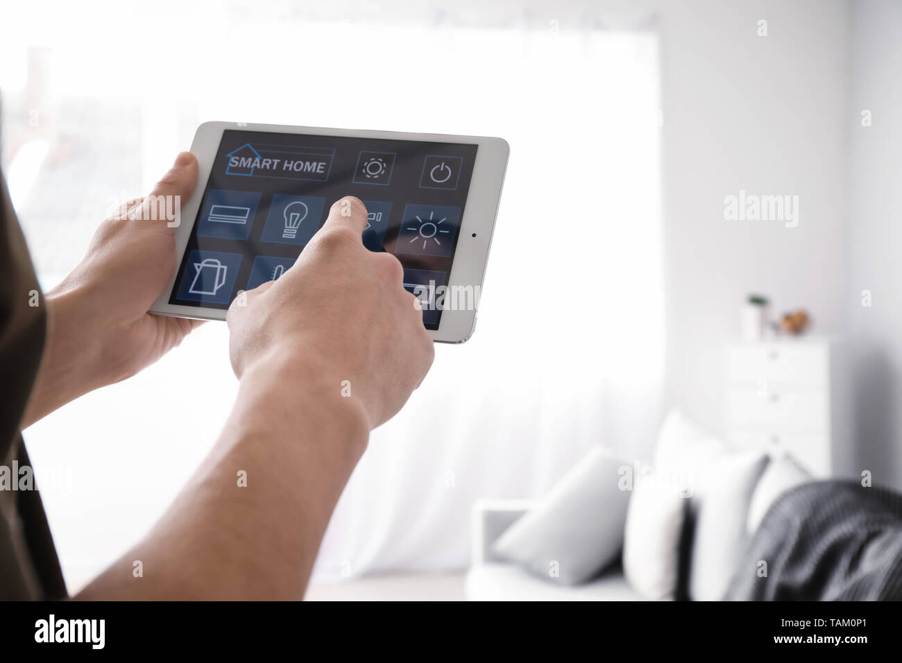 Young man using application of smart home automation Stock Photo - Alamy