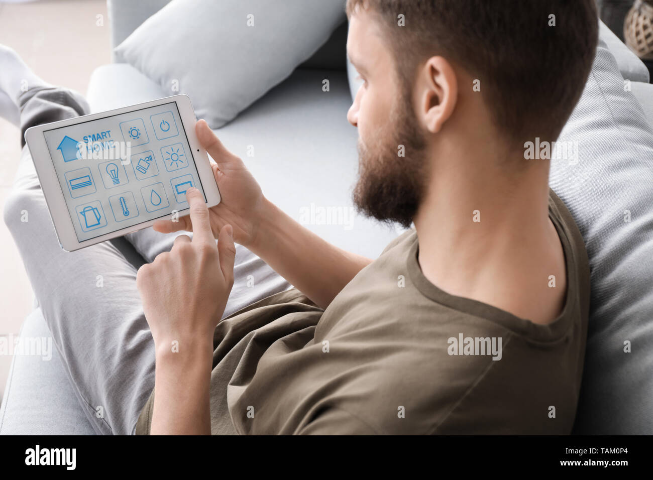 Young man using application of smart home automation Stock Photo - Alamy