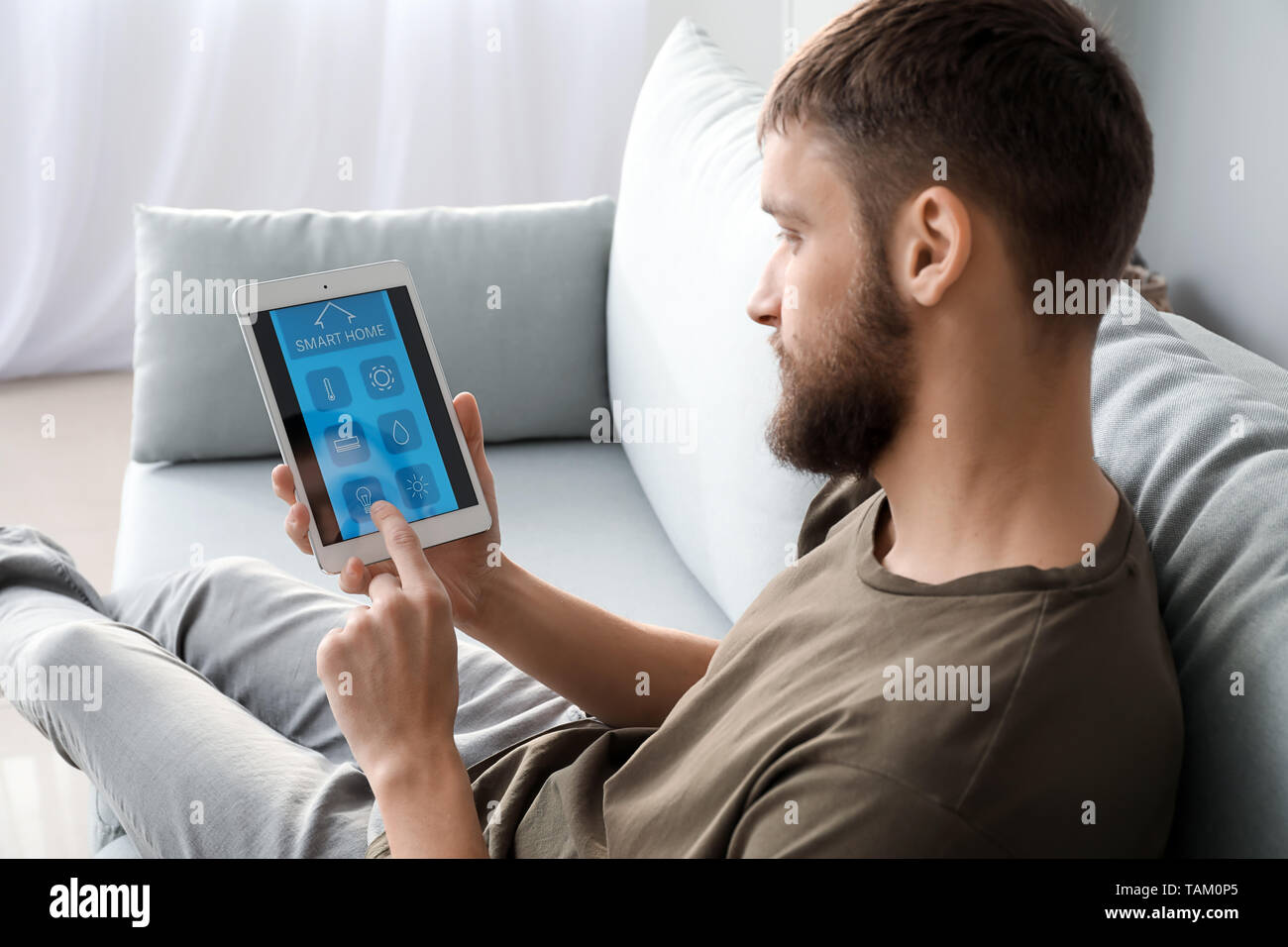 Young man using application of smart home automation Stock Photo - Alamy
