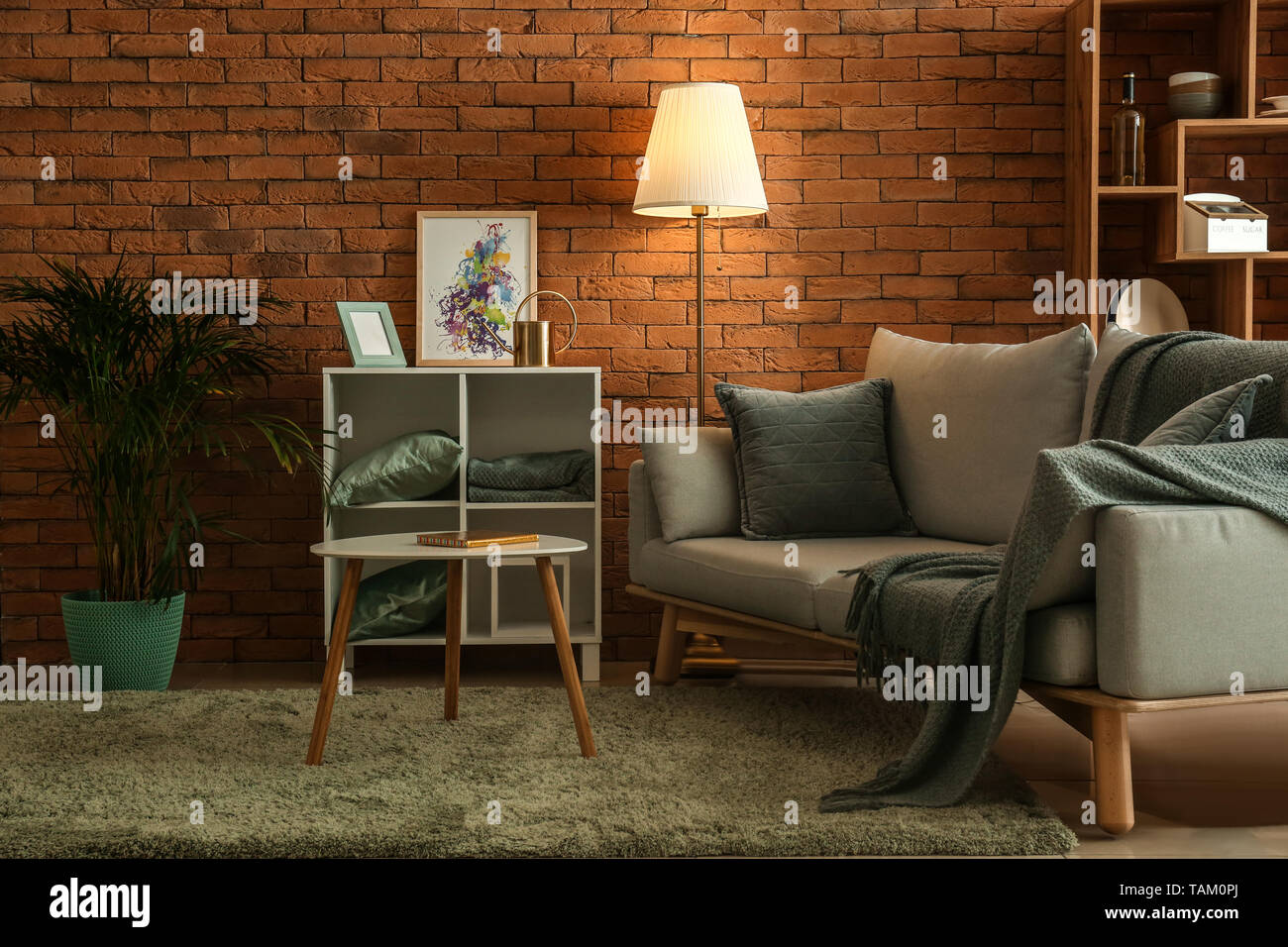 Stylish interior of room with comfortable sofa ad table Stock Photo - Alamy