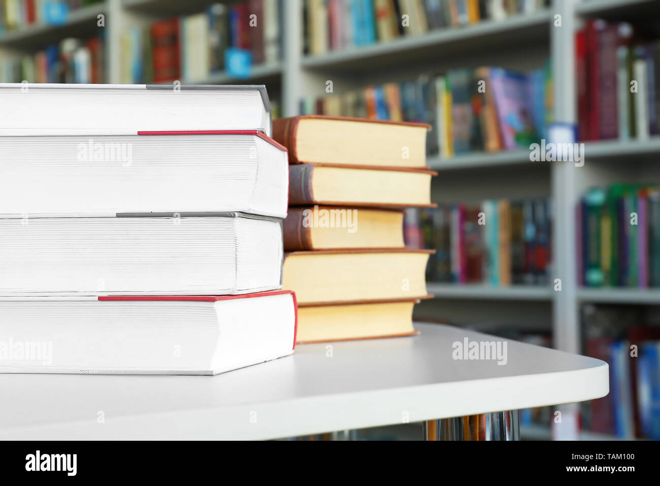 Many books on table in library Stock Photo - Alamy