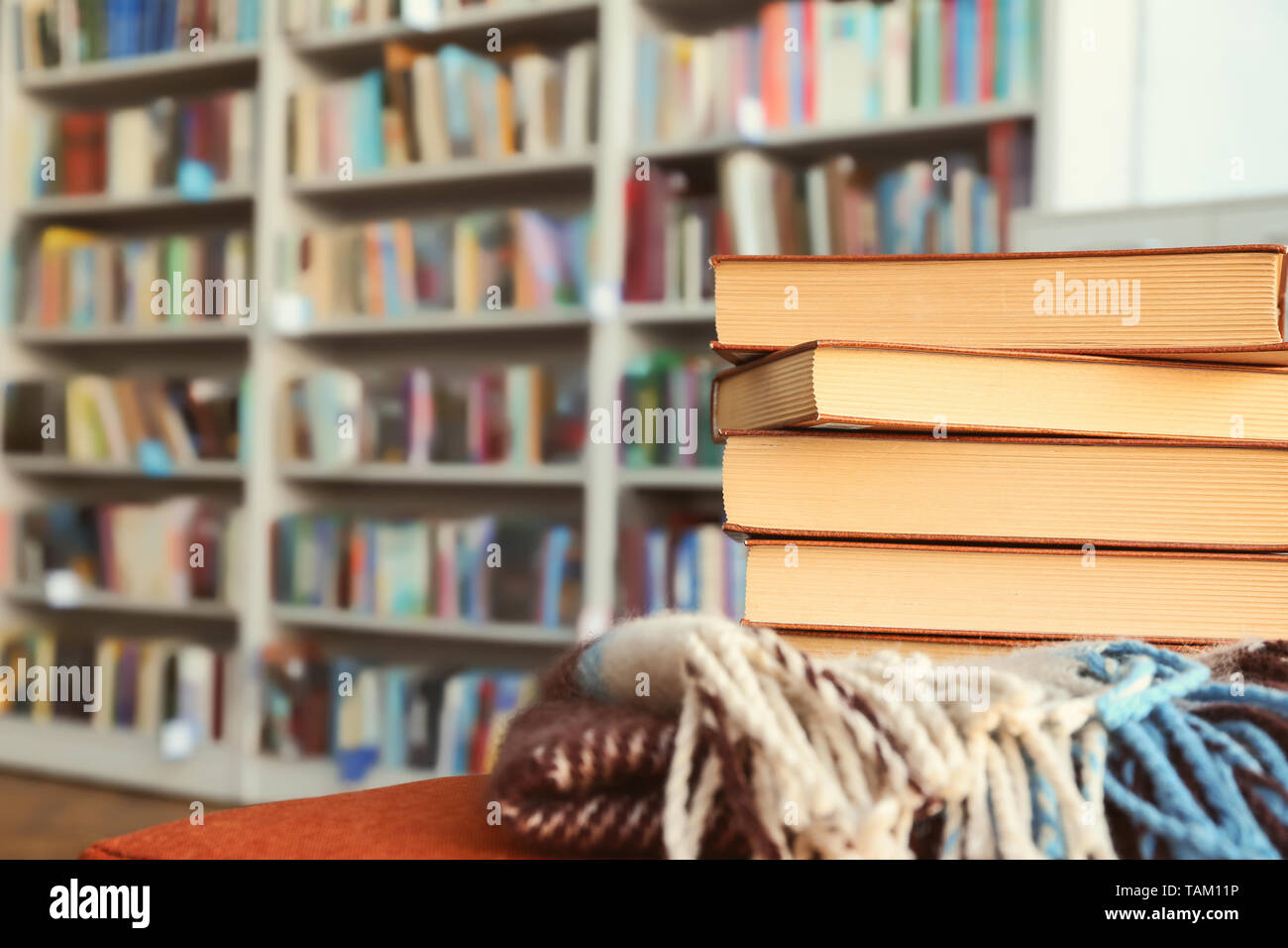 Stack of books on table in library Stock Photo - Alamy
