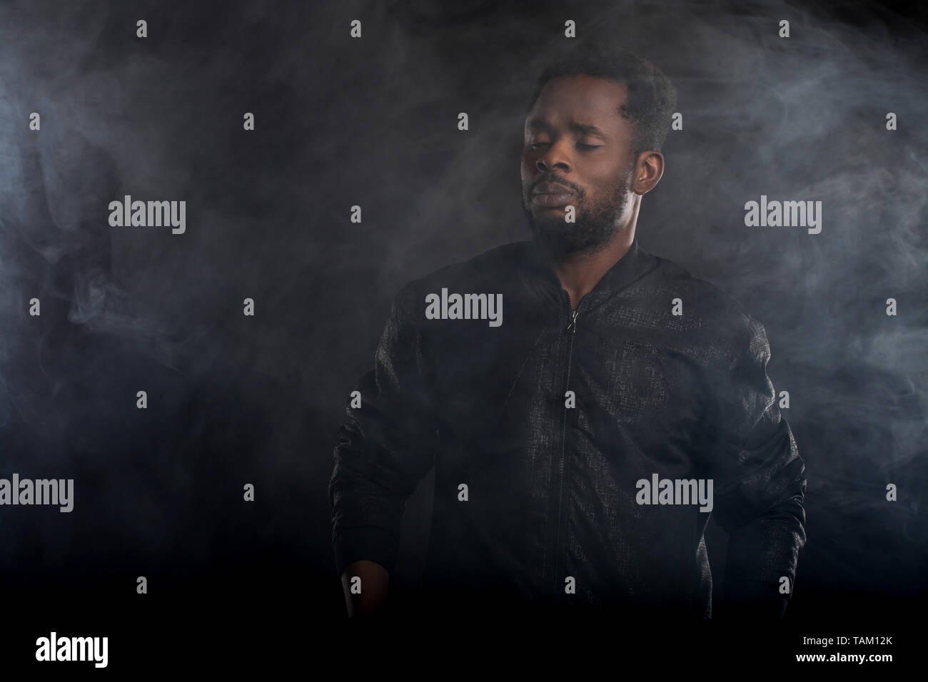 Young cool black man with disco ball over black background. Vertical ...