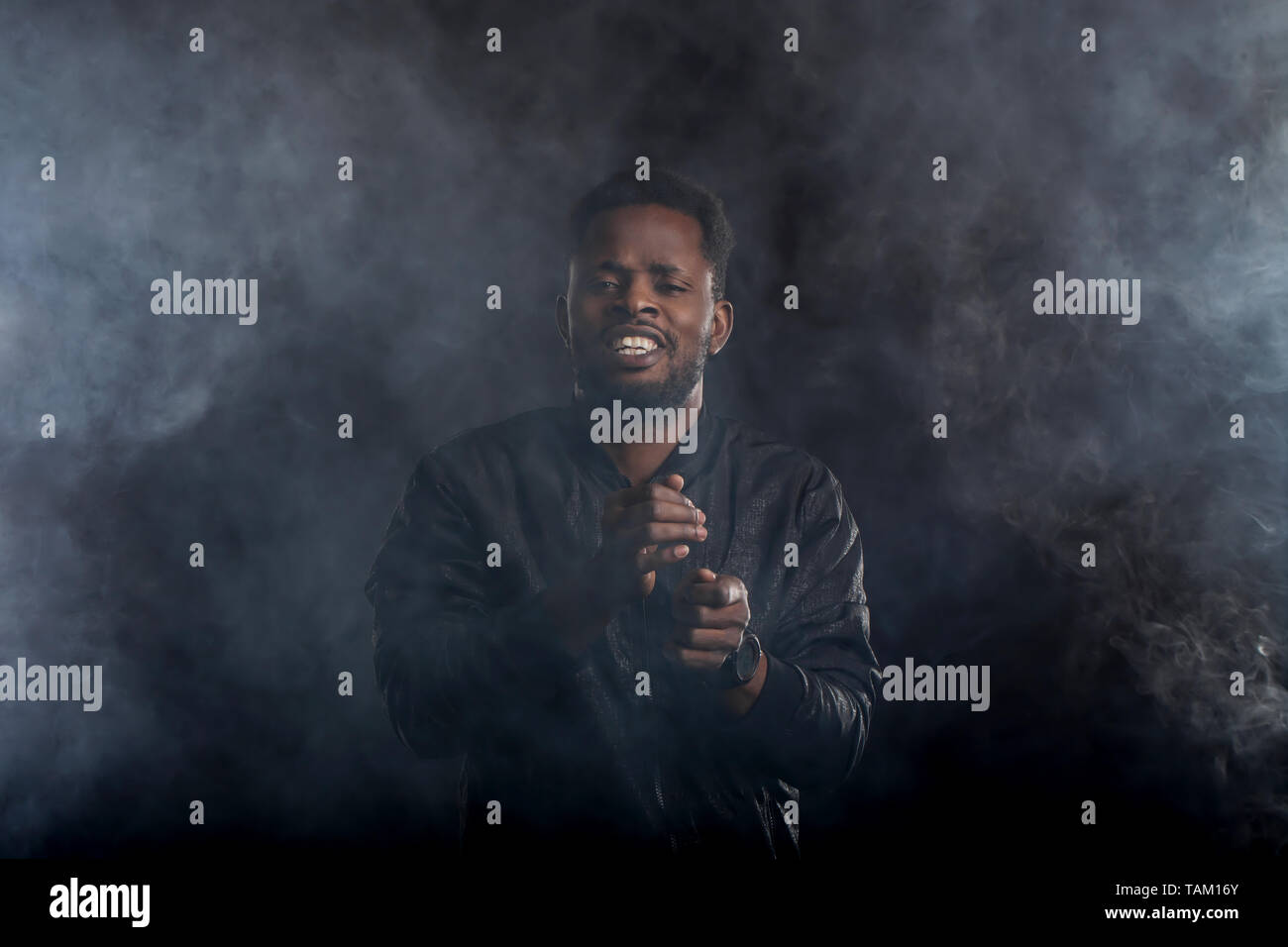 Black man dancing in night club, moving to rhythm of music, raising ...