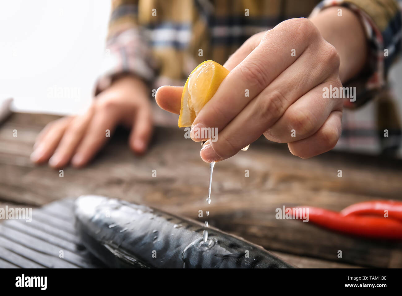 Woman squeezing lemon juice onto tasty mackerel fish, closeup Stock ...