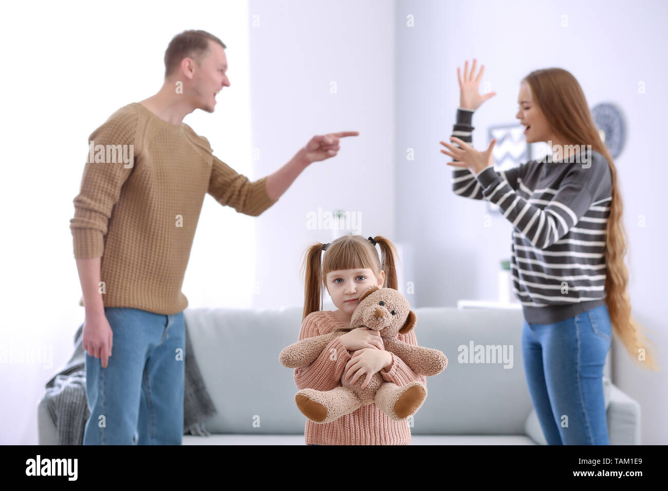 Sad little girl and her quarreling parents at home Stock Photo - Alamy