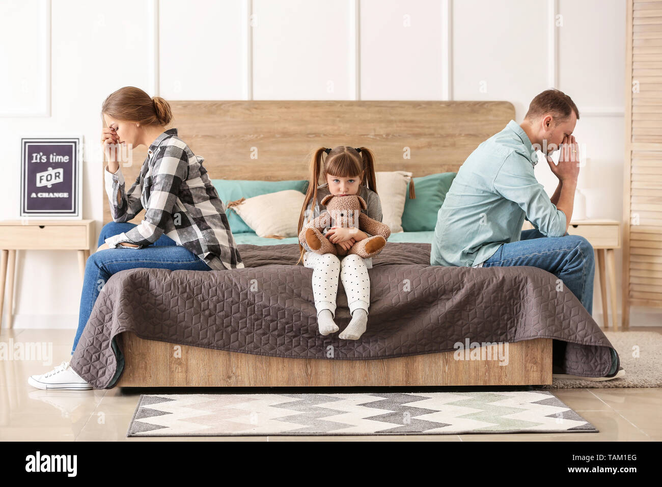 Sad family sitting on bed after quarrel Stock Photo - Alamy