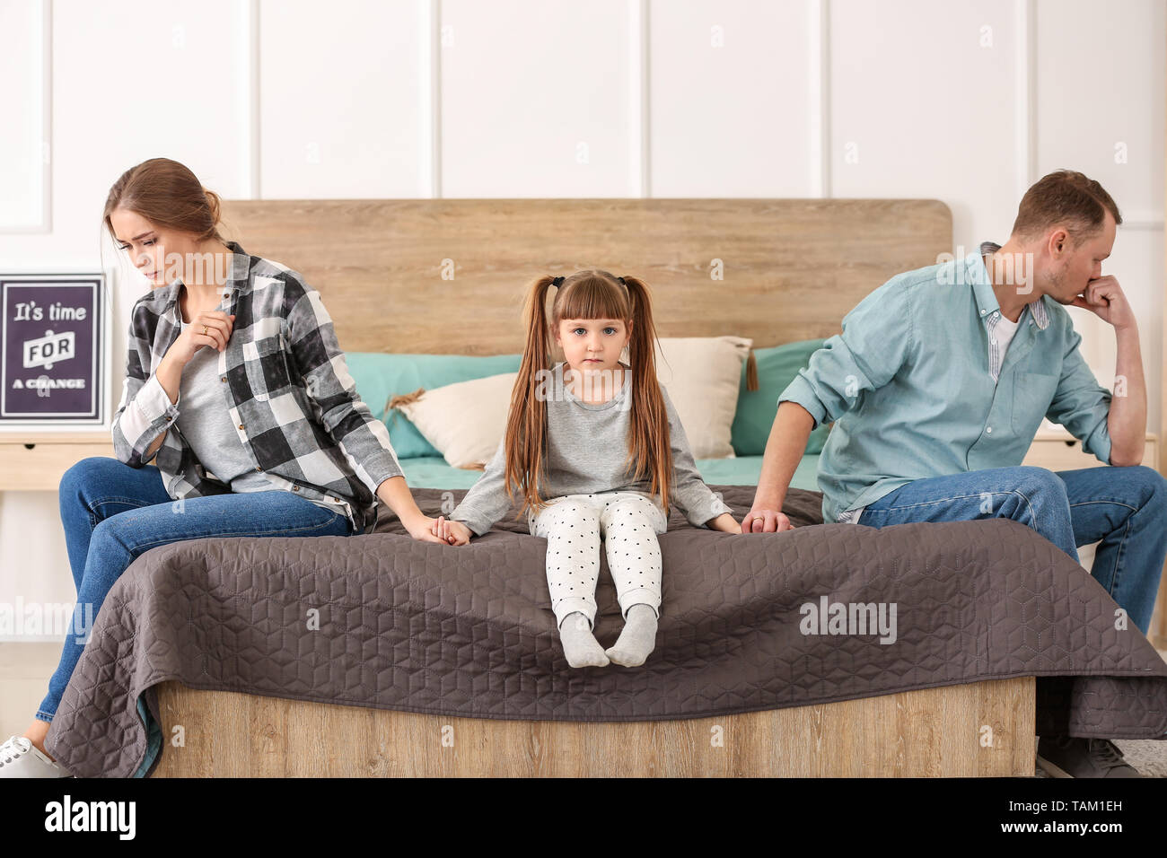 Sad family sitting on bed after quarrel Stock Photo - Alamy