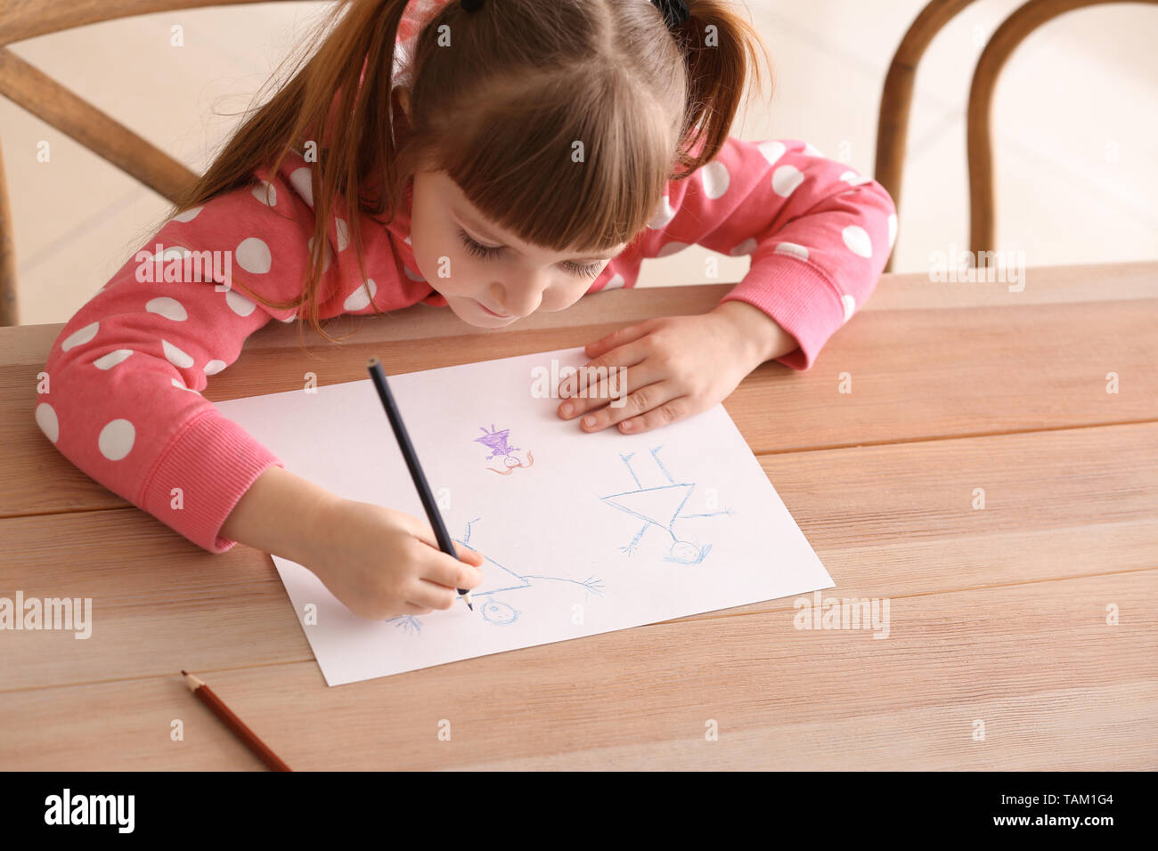 Little girl drawing family she is dreaming about after her parents ...