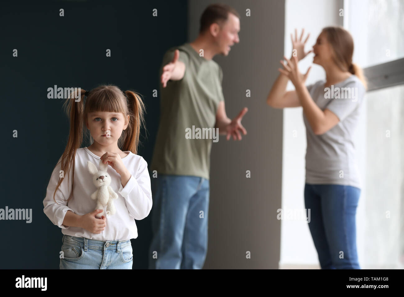 Sad little girl and her quarreling parents at home Stock Photo - Alamy
