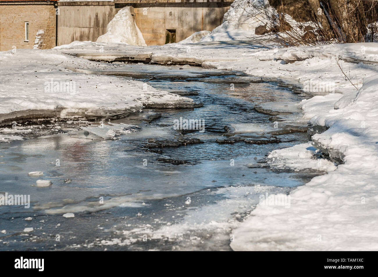 Spring thawed patch in the ice of the river. Frozen ice and snow by the ...