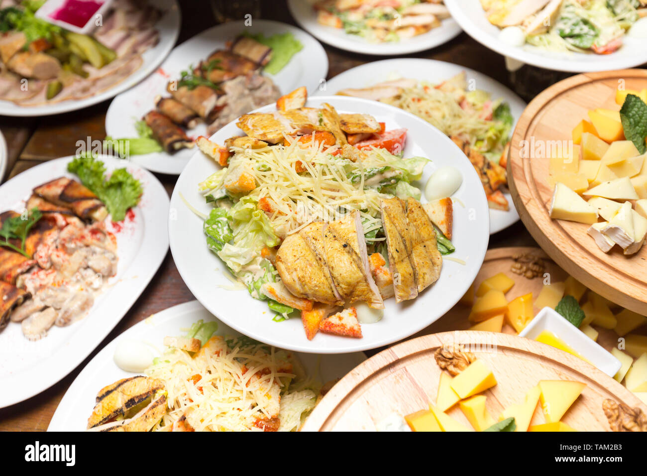 many plates of food on the holiday table. cold appetizers and salads in ...