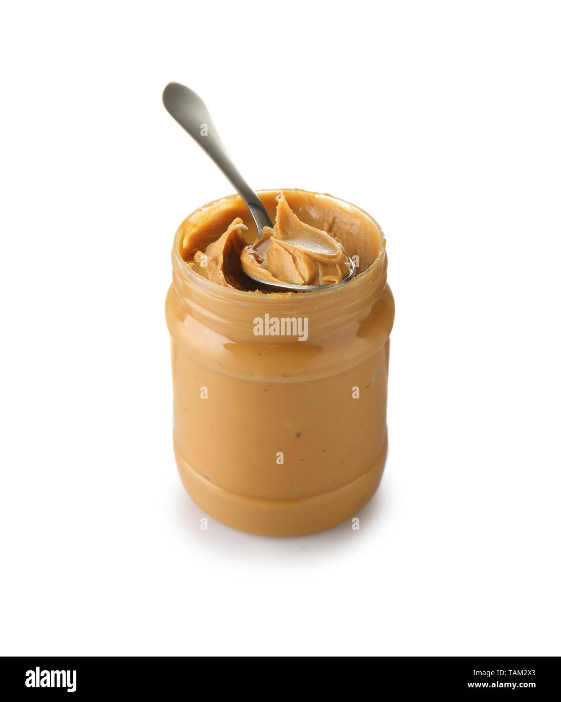 Jar and spoon with tasty peanut butter on white background Stock Photo ...