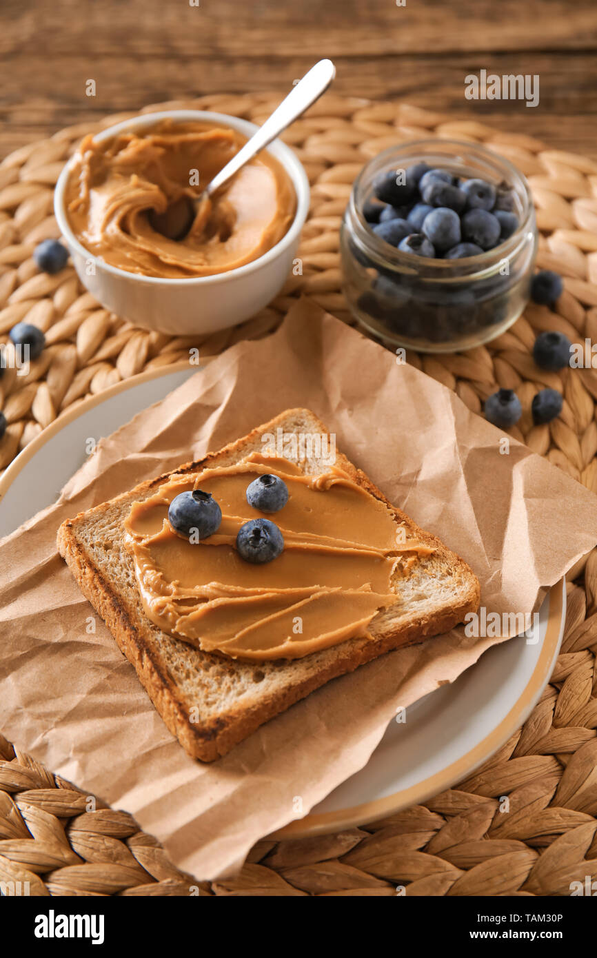 Toasted bread with tasty peanut butter and berries on table Stock Photo ...