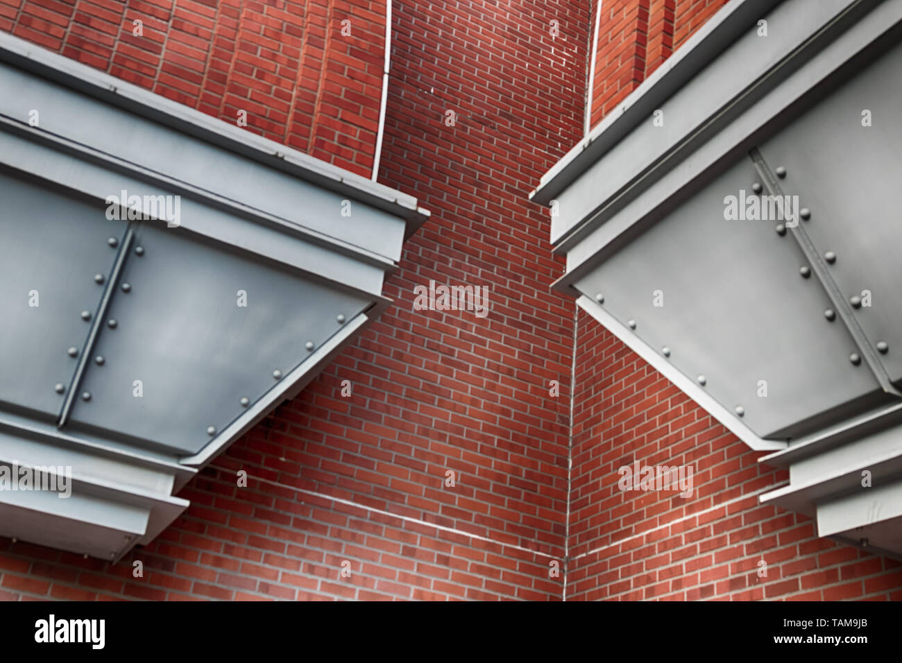 Abstract modern brick building corner with steel flutes in daylight ...
