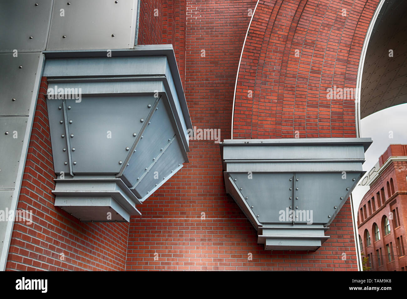 Abstract modern brick building corner with steel flutes in daylight ...