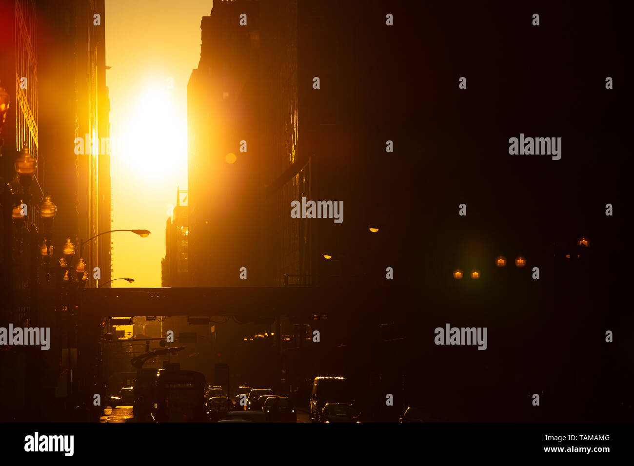 Orange sun setting between buildings in downtown Chicago Stock Photo ...