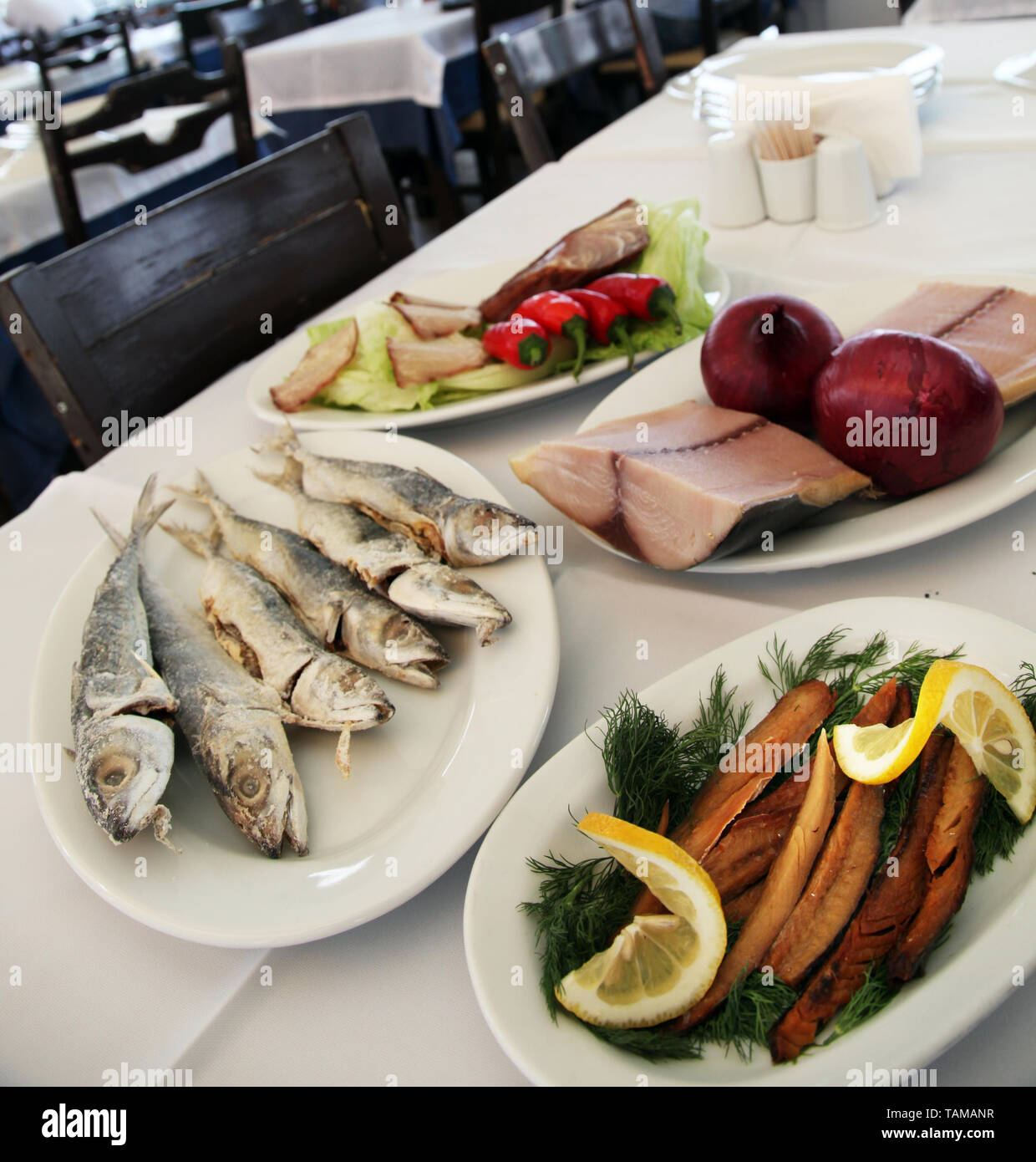 Fried bonito fish, dried cod and pickled tunny on the restaurant table ...