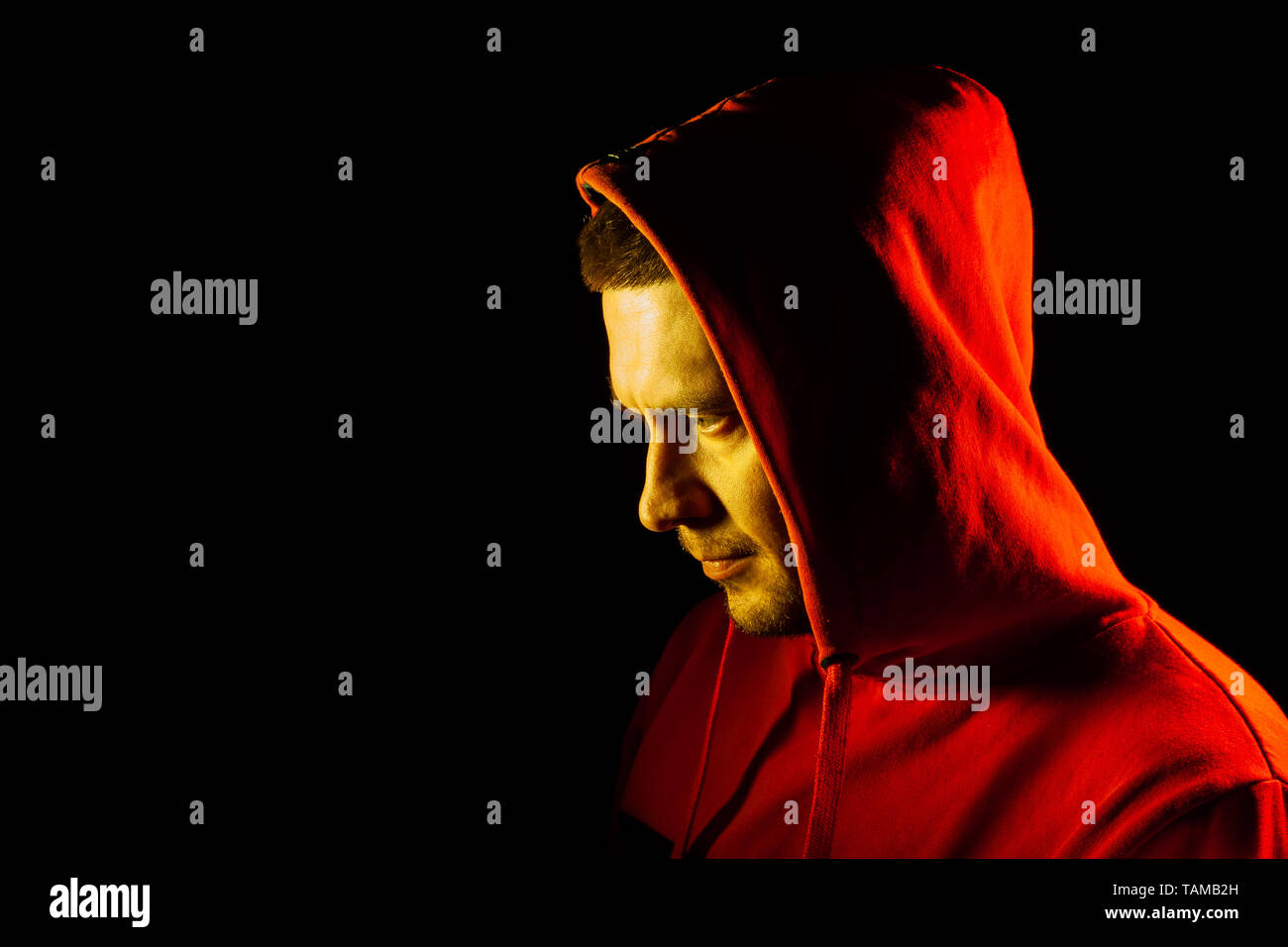 Close-up of the head of a man in an orange hood on the side of the side ...