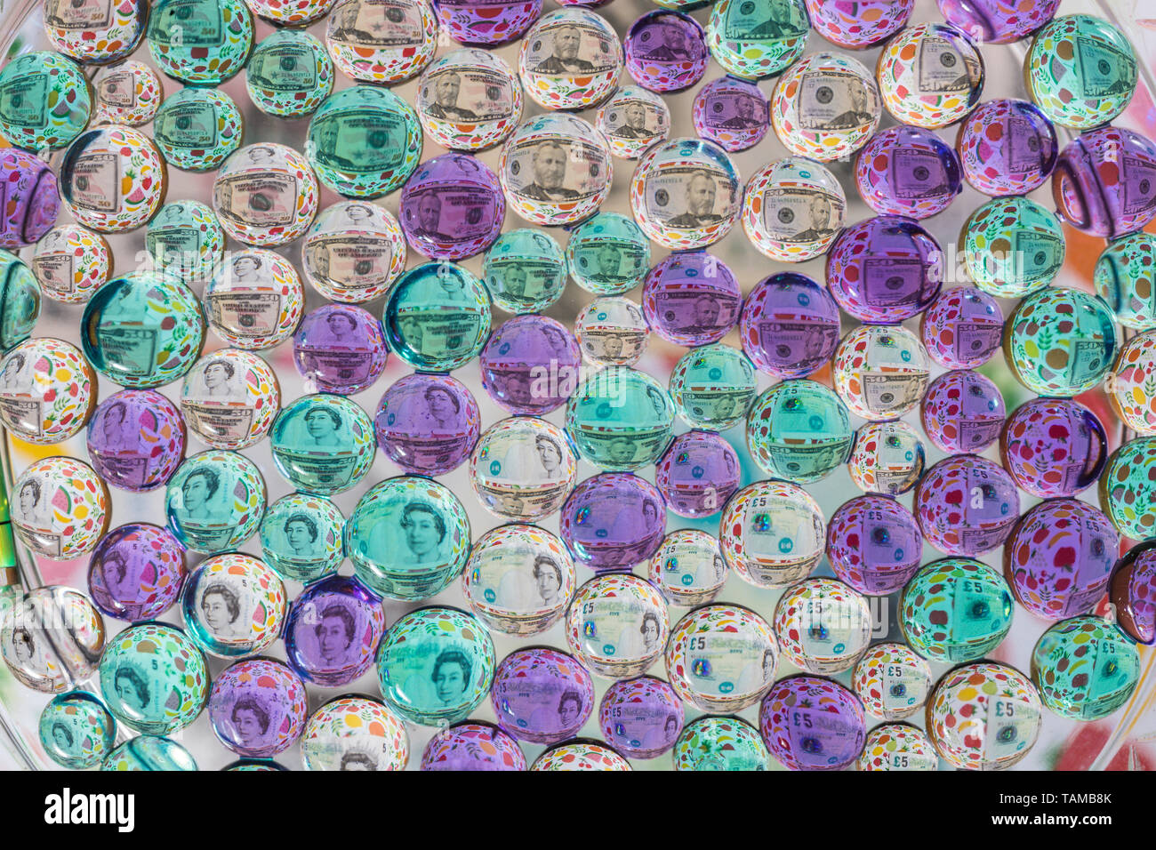 5 pound british note with 50 usd bill refracted through marble-sized ...